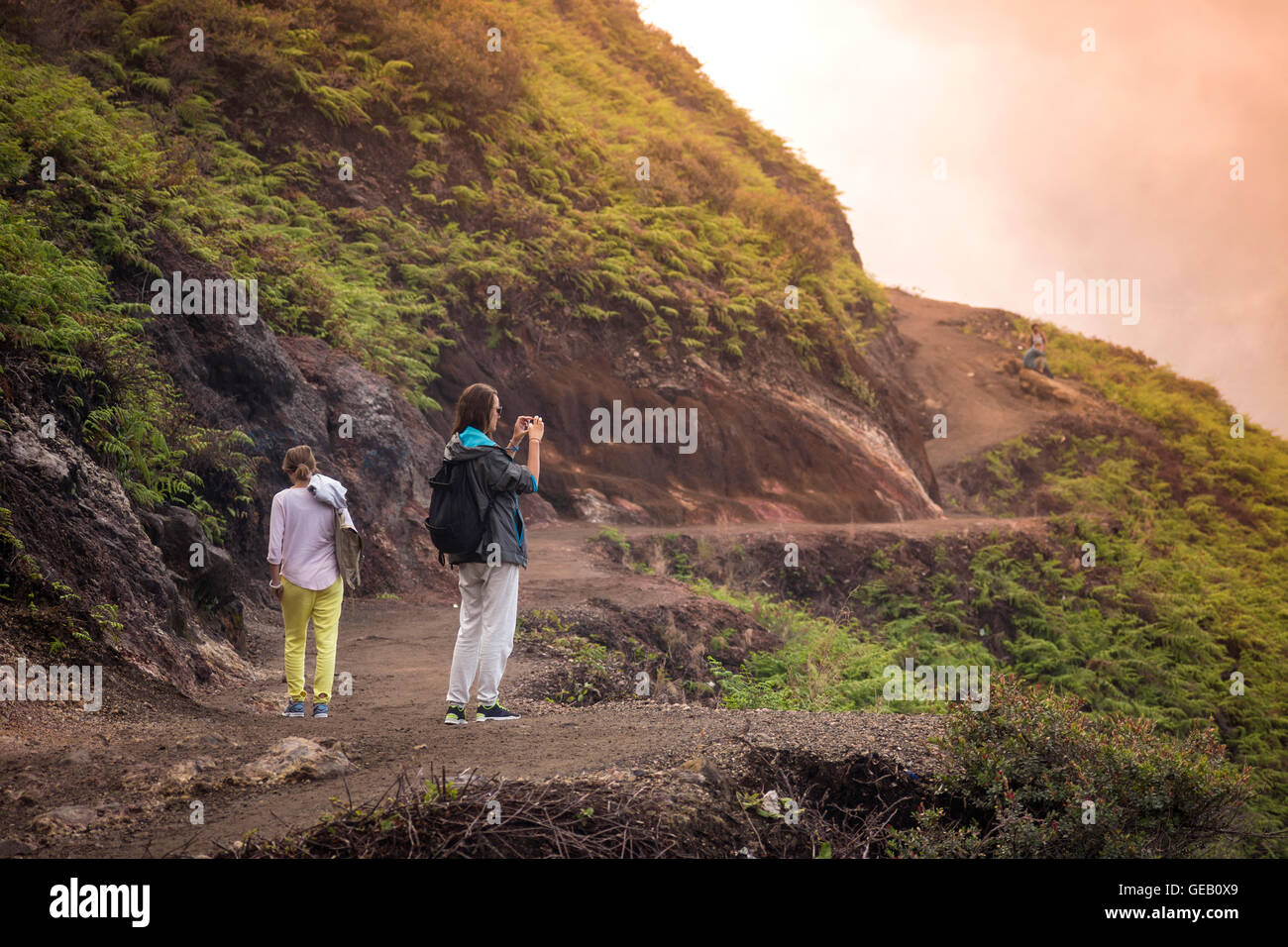 Indonesia, Java, Two women hiking in the mountains and taking pictures ...