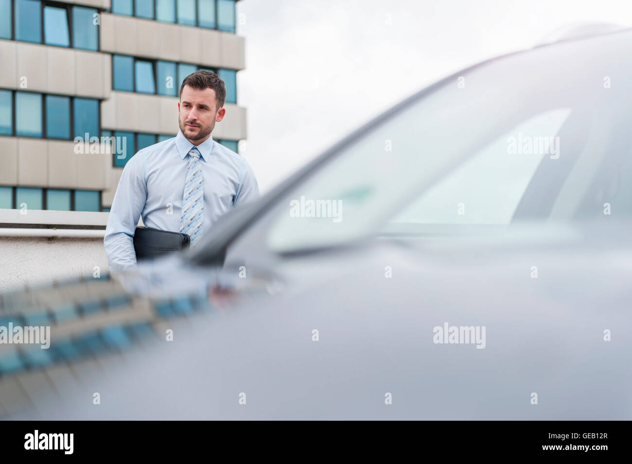 Businessman at car on parking lot Stock Photo - Alamy
