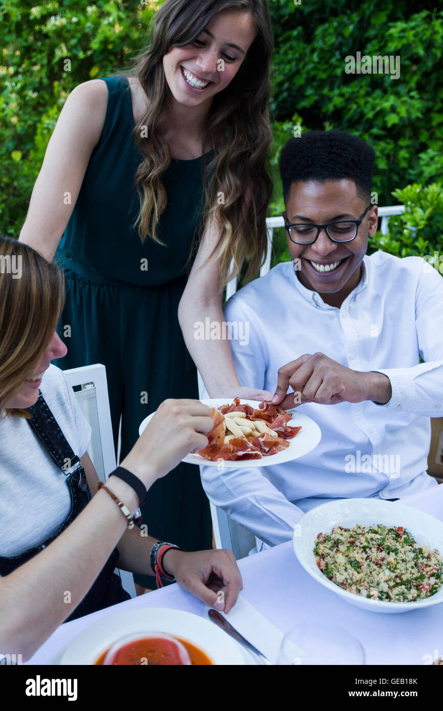 Woman offering spanish ham to her guests during a summer dinner Stock ...