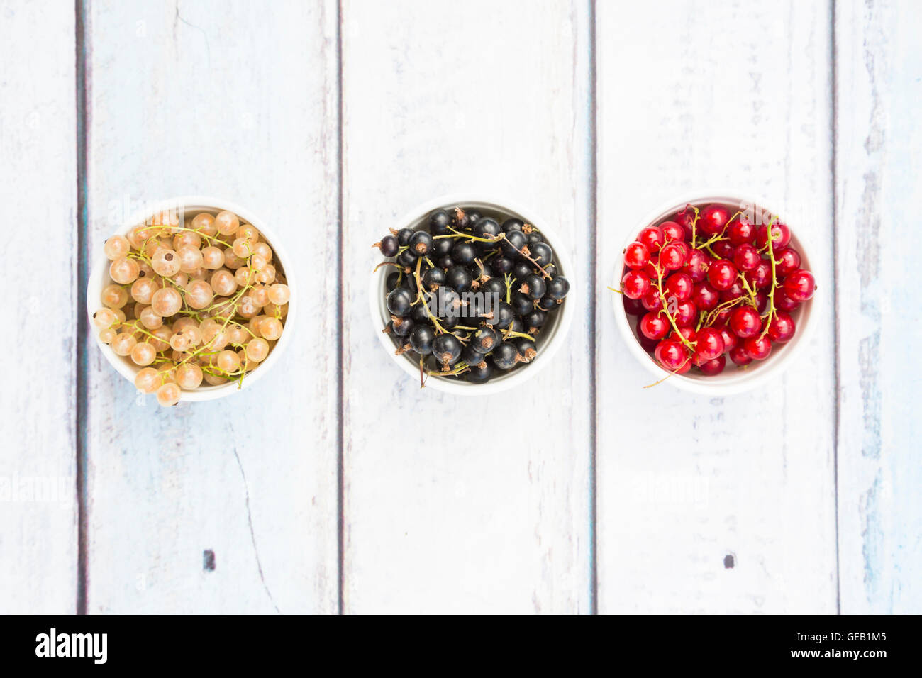 Row of three bowls with black, red and white currants Stock Photo - Alamy