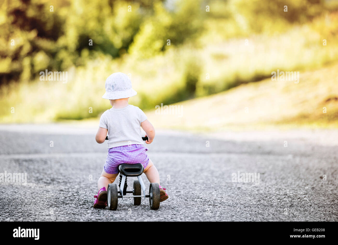 Back view of toddler girl on toy car Stock Photo - Alamy