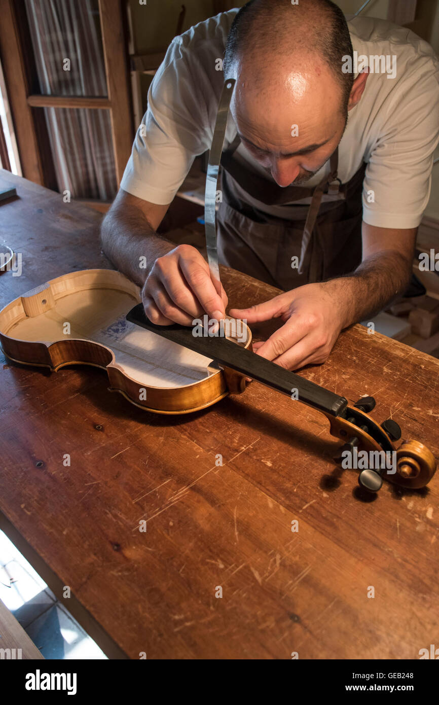 Luthier making measurements during the manufacture of a violin in his ...