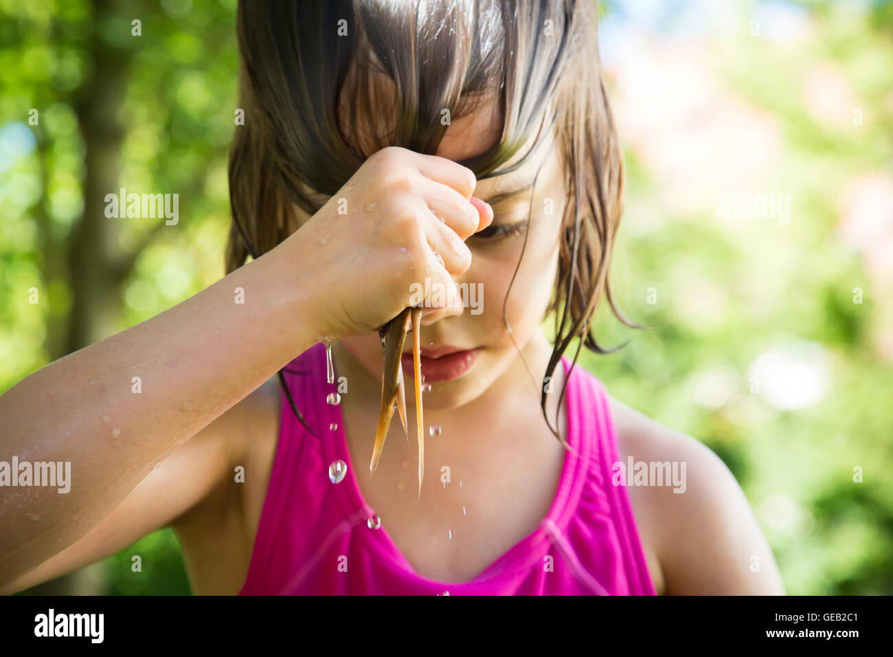 Little girl wringing out her wet hair Stock Photo - Alamy