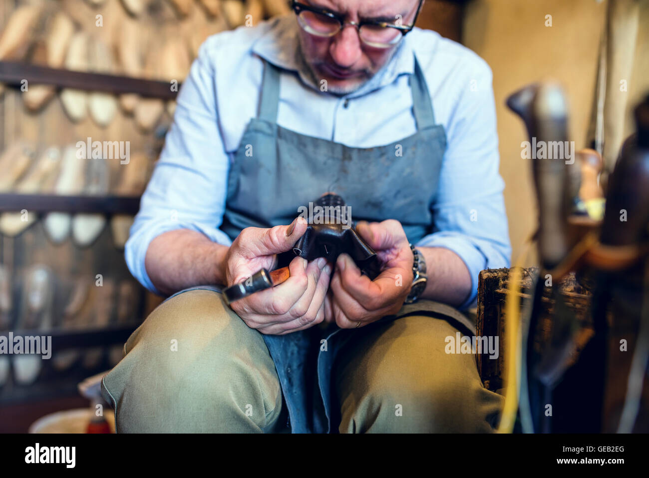 Cobbler making shoes in his workshop Stock Photo - Alamy