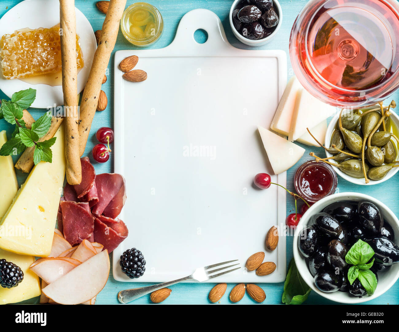 Summer wine snack set. Glass of rose, meat, cheese, olives, honey ...