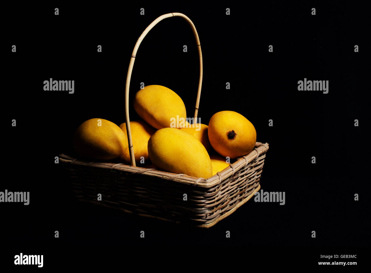 Fresh ripe chaunsa mangoes with basket on black background Stock Photo ...