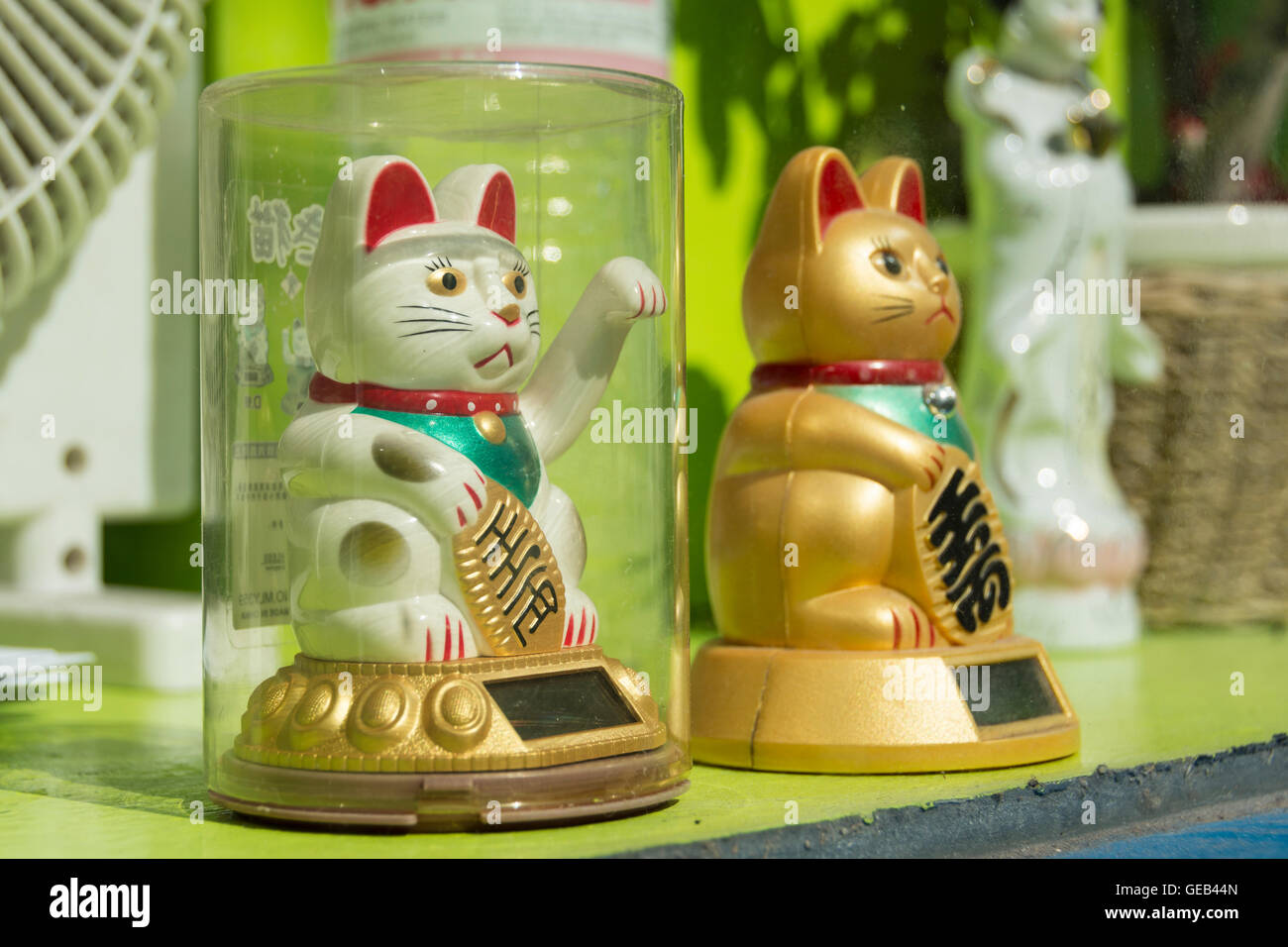 Maneki Neko (Japanese beckoning cats) in bright sunlight on red ...
