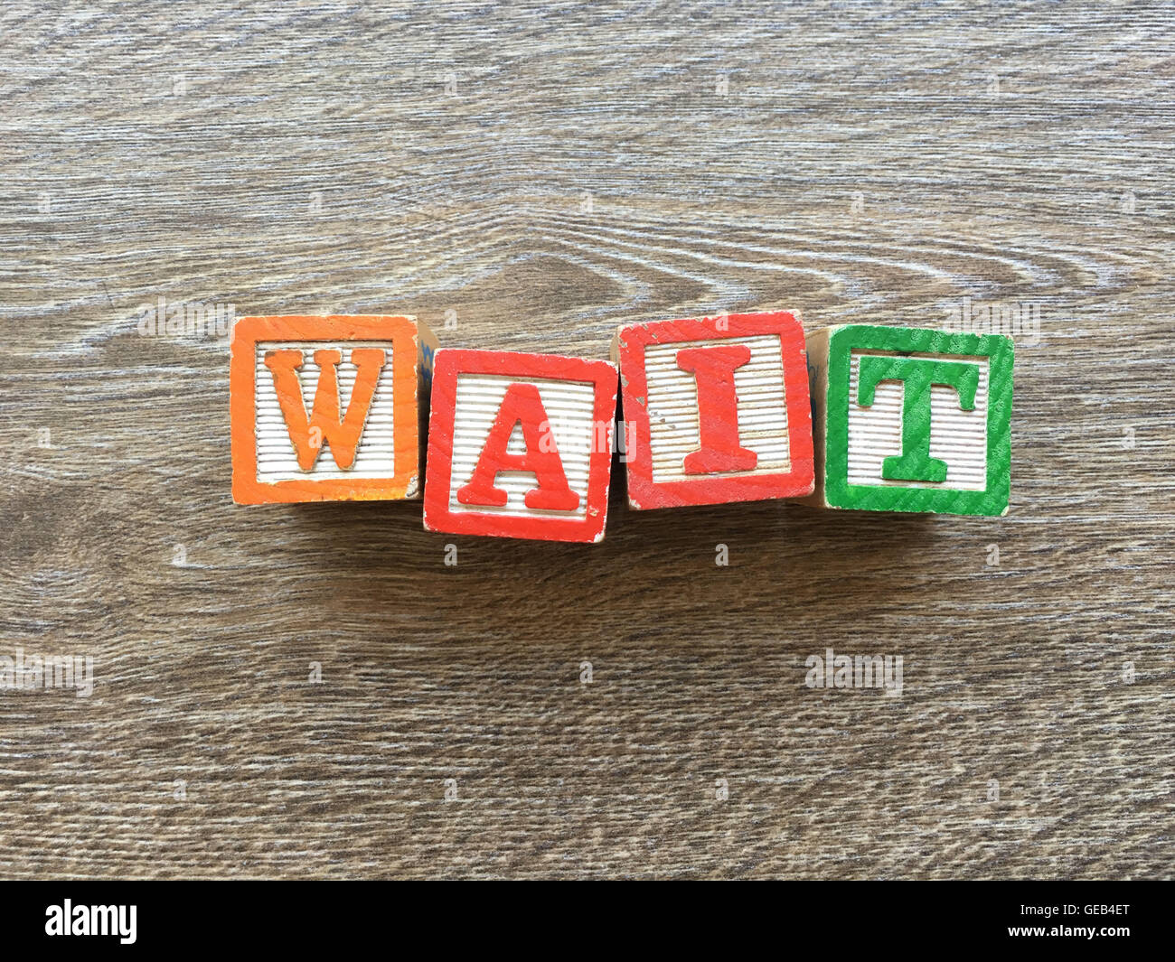 Alphabet wood block letters forming the verb WAIT, combining those toys ...