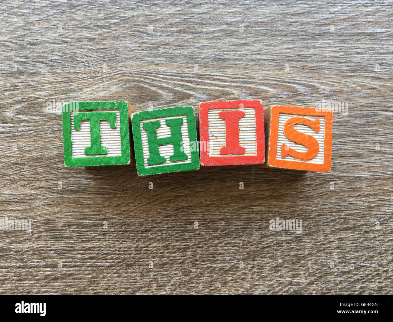 Alphabet wood block letters forming the word THIS, combining those toys ...