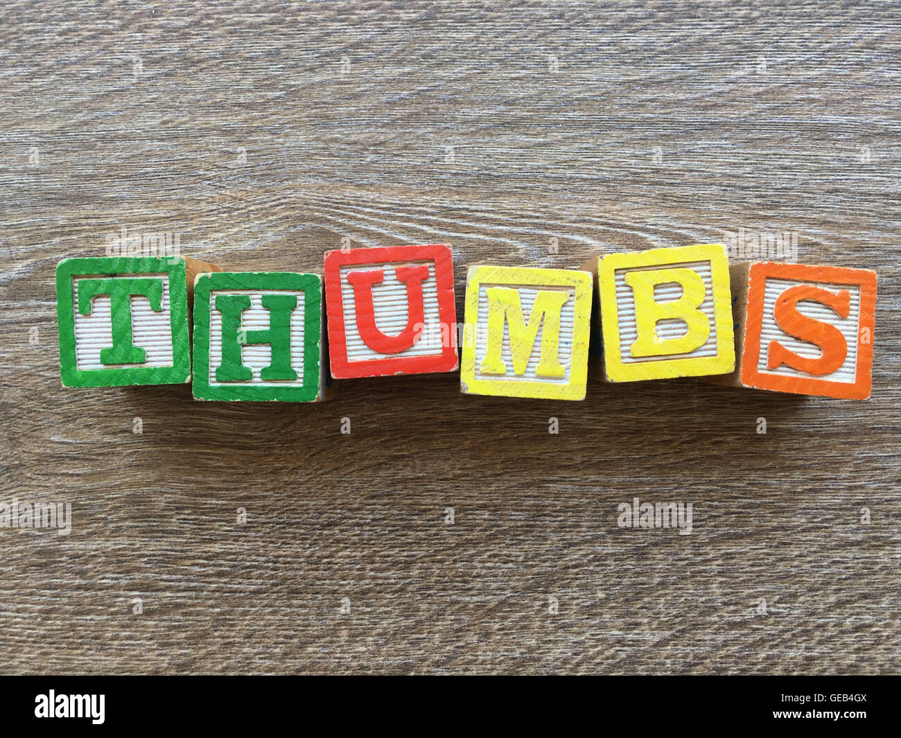 Alphabet wood block letters forming the word THUMBS, combining those ...