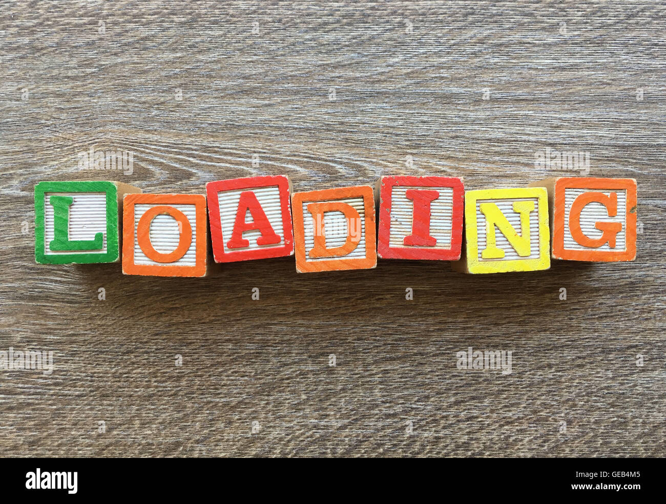 Alphabet wood block letters forming the word LOADING, combining those ...