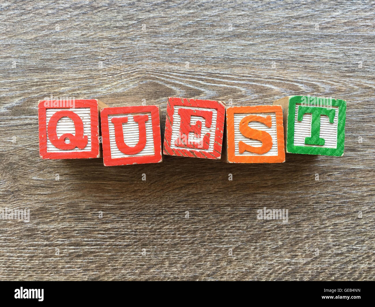 Alphabet wood block letters forming the word QUEST, combining those ...
