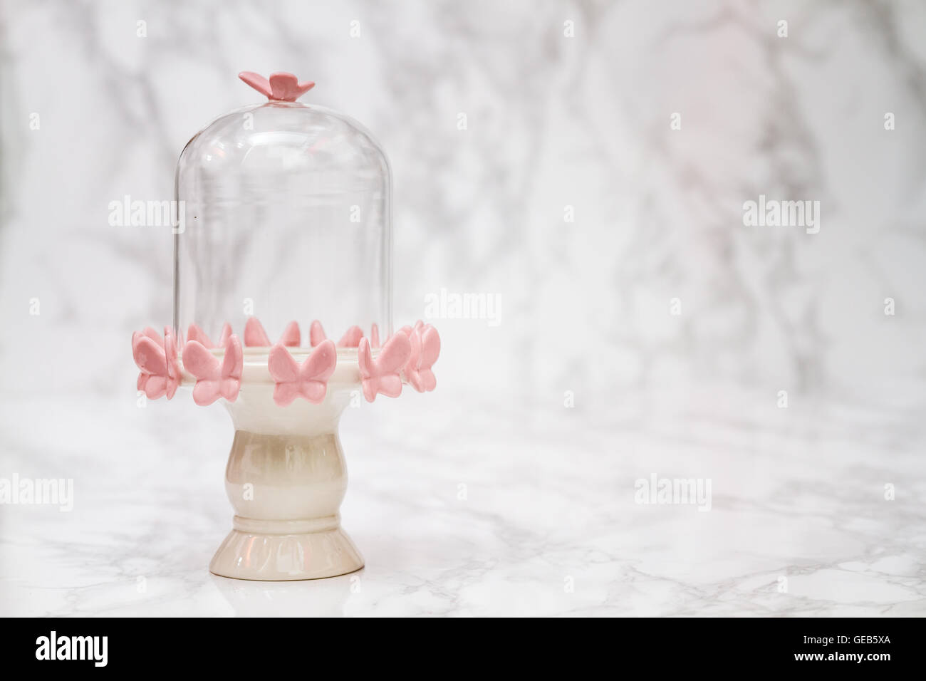 Empty bell jar with pink butterfly design on white marble Stock Photo ...