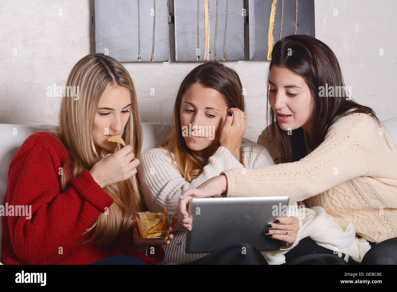 Portrait of three and beautiful young friends having fun and using ...