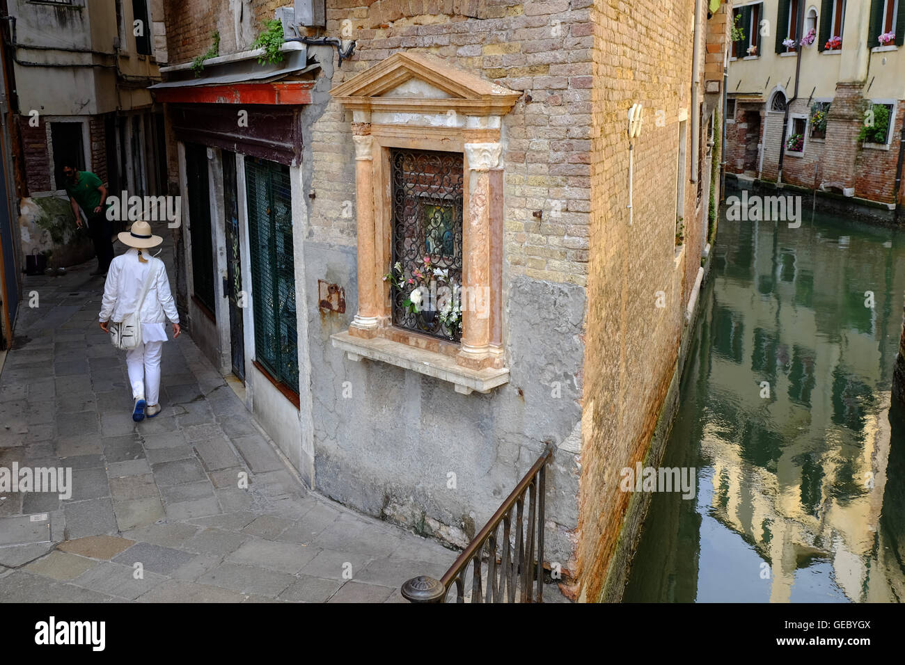 Woman walking by a shrine of devotion Venice Italy Stock Photo - Alamy