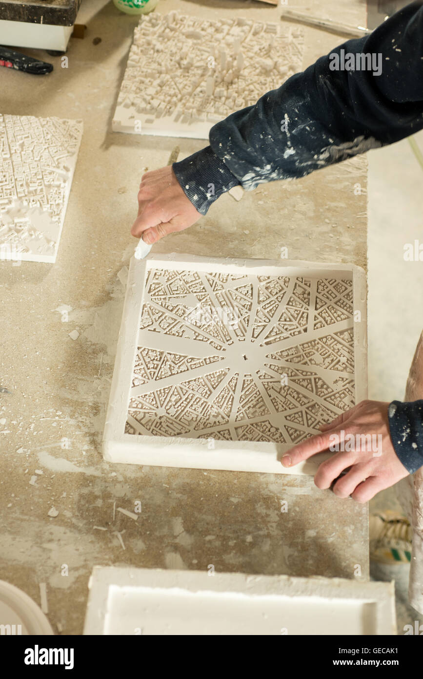 Hands working on a city map model made of plaster Stock Photo - Alamy