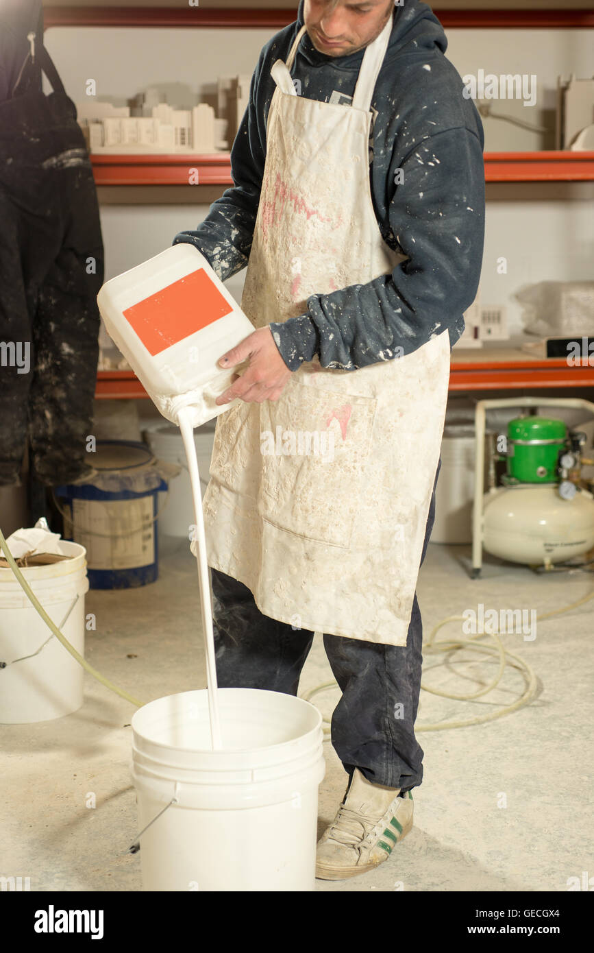 Man pouring white liquid into a huge plastic bucket Stock Photo - Alamy
