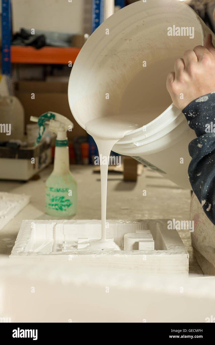 A bucket of liquid plaster poured onto open rectangular mold Stock ...