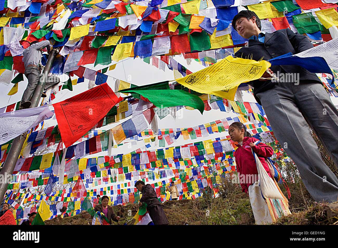 People during Losar, new year, hanging Tibetan prayer flags in Lhagyal ...