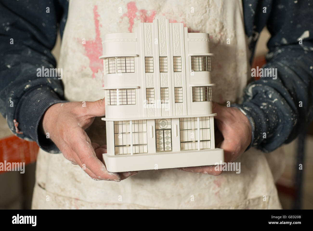 A plaster scale model of a known architectural building held with two ...