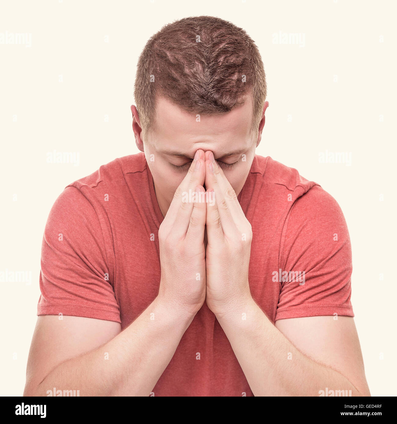 Young man is praying concentrated on white background. Toned photo ...