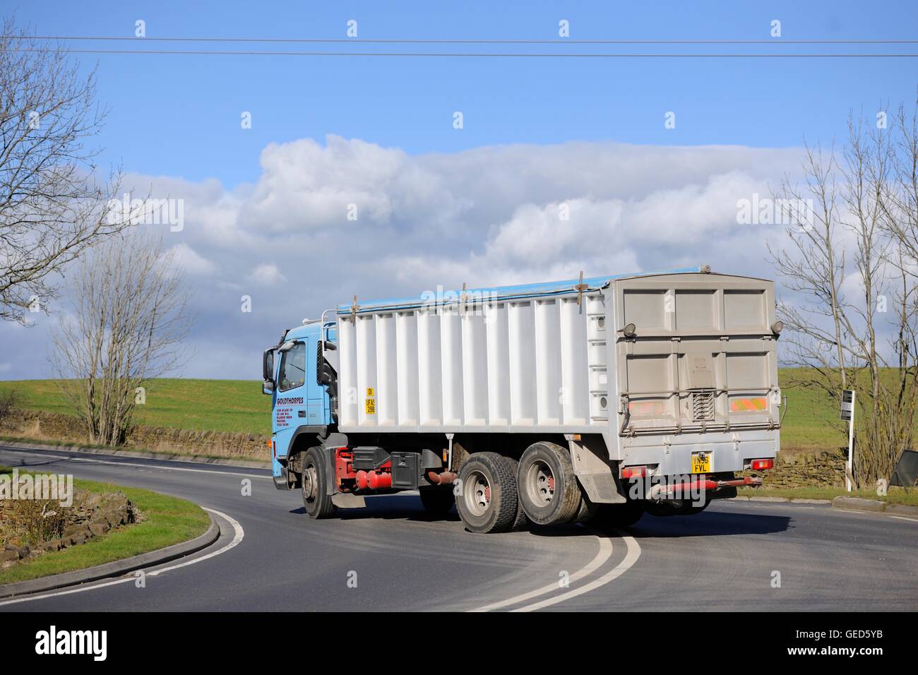 Bulk tipper aggregates truck, driving empty, turning a corner onto a ...