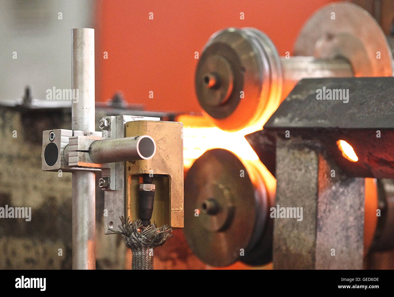 Moving the heated metal rod through the rollers in rolling mill Stock ...