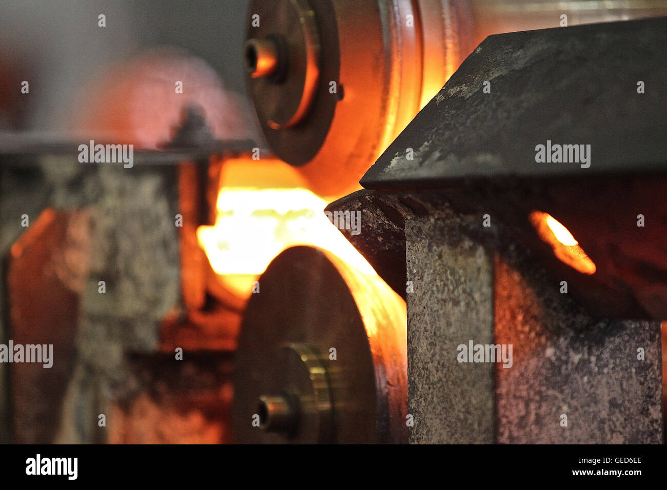 Moving the heated metal rod through the rollers in rolling mill Stock ...