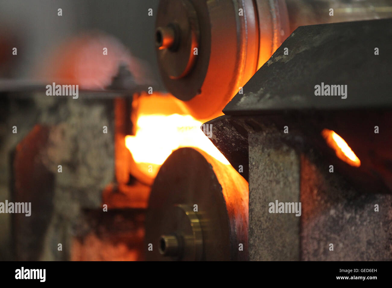 Moving the heated metal rod through the rollers in rolling mill Stock ...