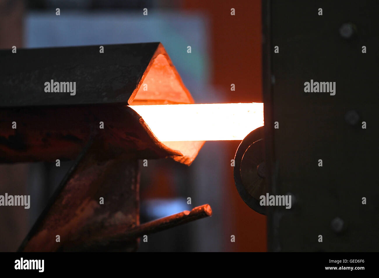 Moving the heated metal rod through the rollers in rolling mill Stock ...