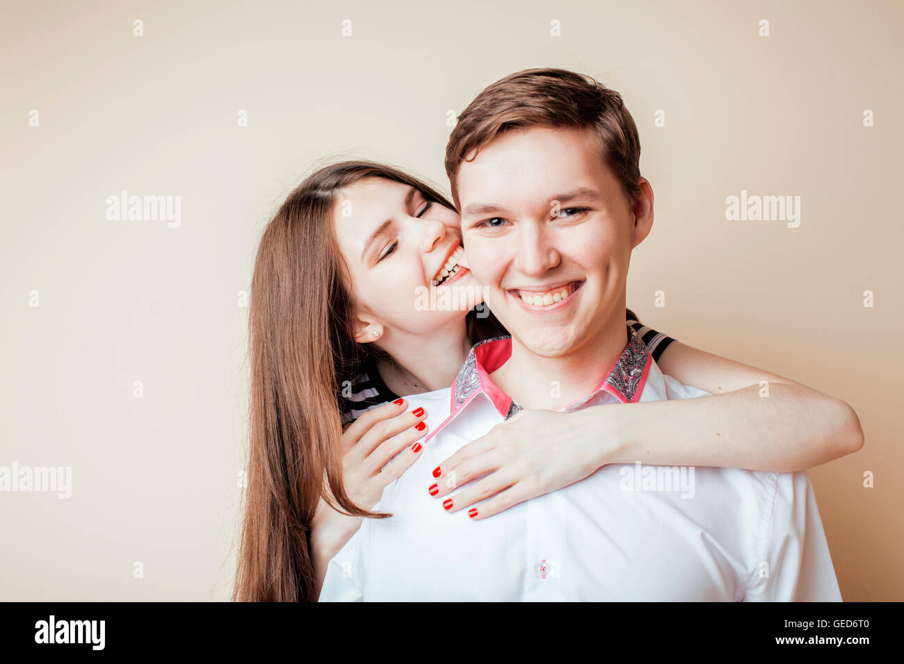 couple of happy smiling teenagers students, warm colors having a kiss ...
