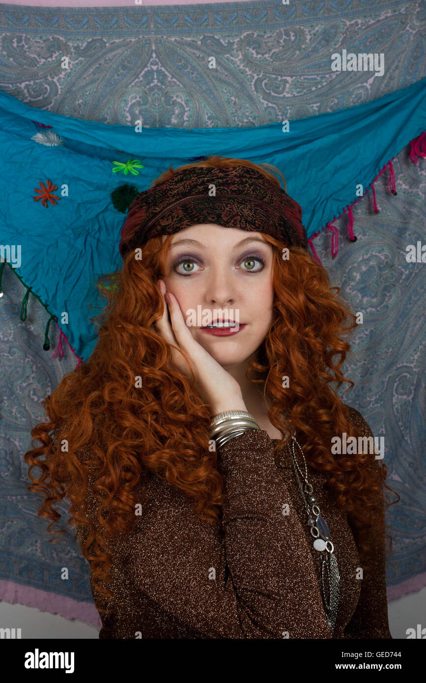 Beautifiul young woman with long curly red hair dressed as a gypsy ...