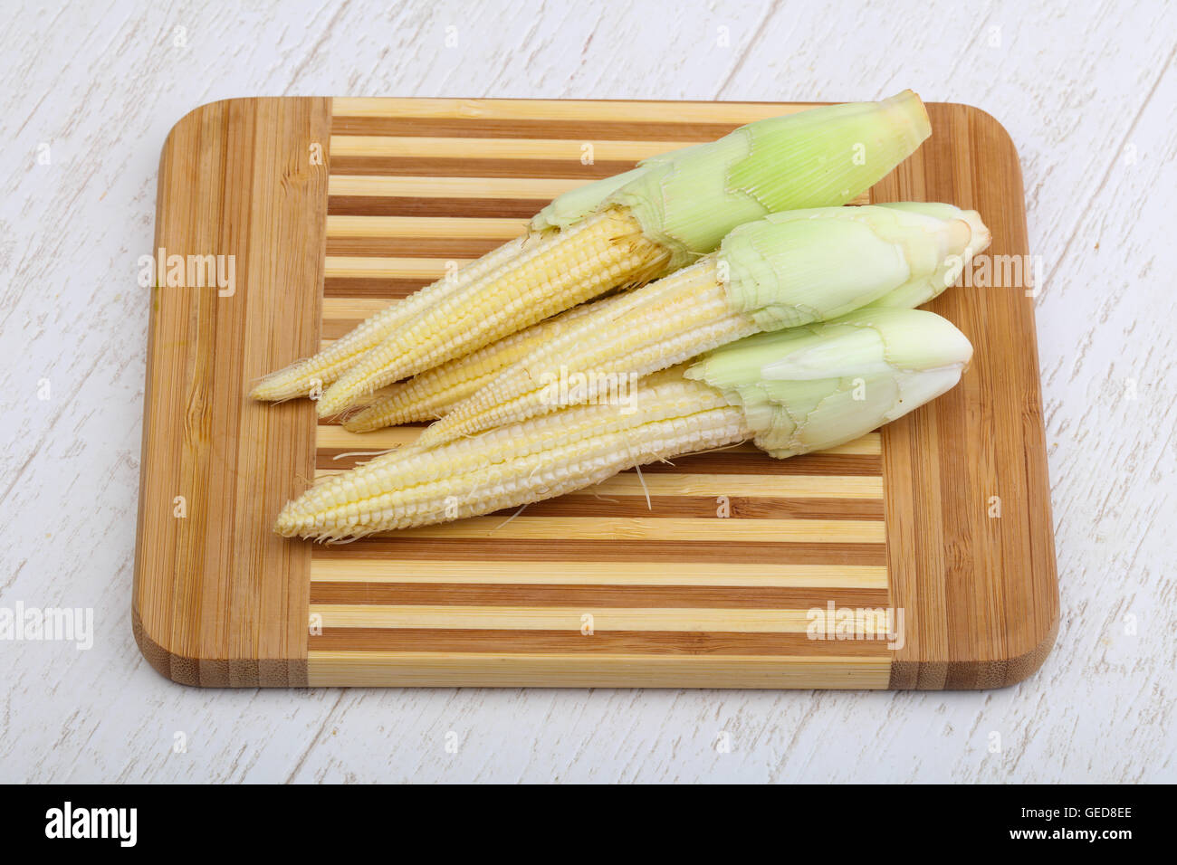 Fresh baby corn heap on the wood background Stock Photo - Alamy