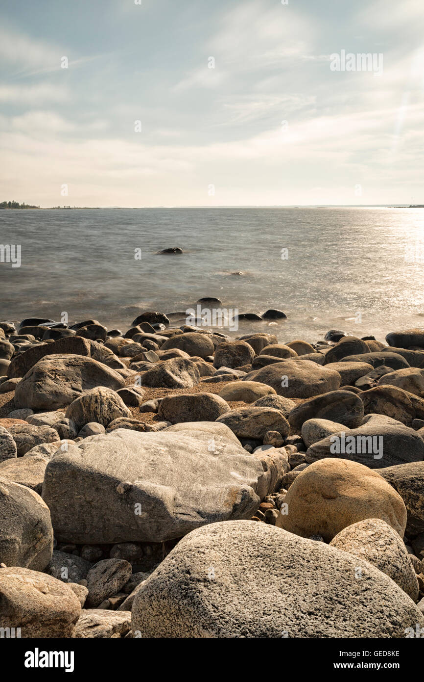 Rocky Shoreline over Ocean with a partly cloudy sky Stock Photo - Alamy