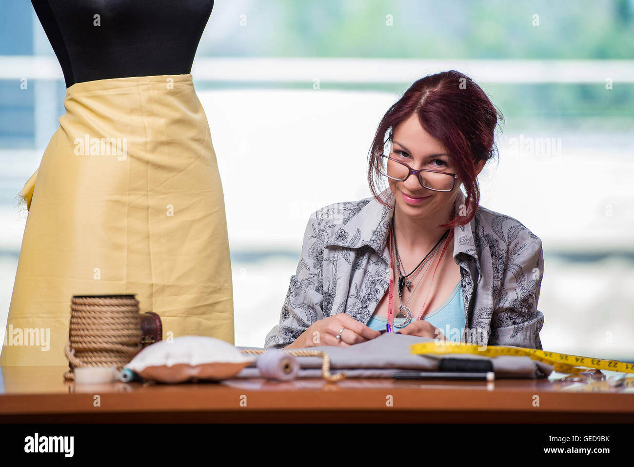 Woman tailor working at her desk Stock Photo - Alamy