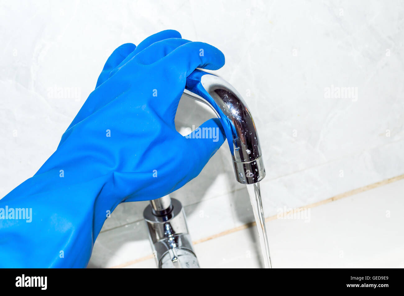 water tap with blue Blue gloves hand Stock Photo - Alamy
