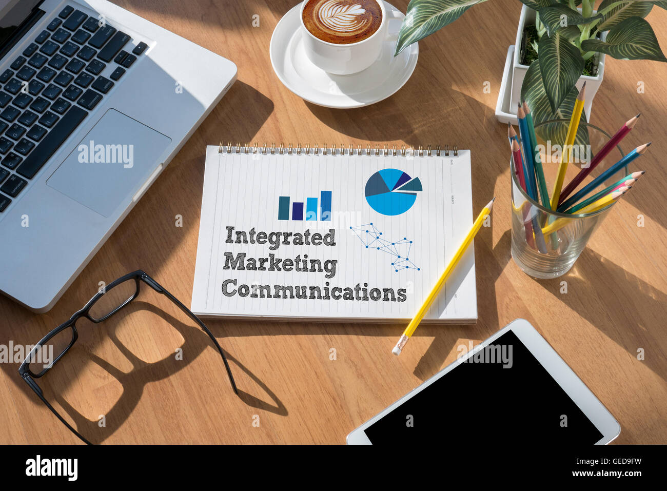 integrated marketing communications (IMC) open book on table and coffee ...