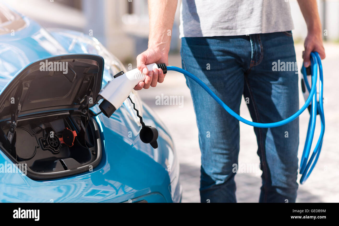 Man turning on charging of car Stock Photo - Alamy