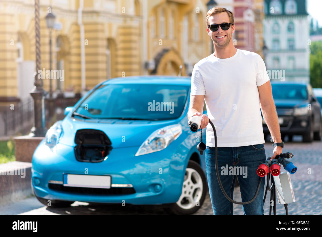 Man with cables in front of car Stock Photo - Alamy