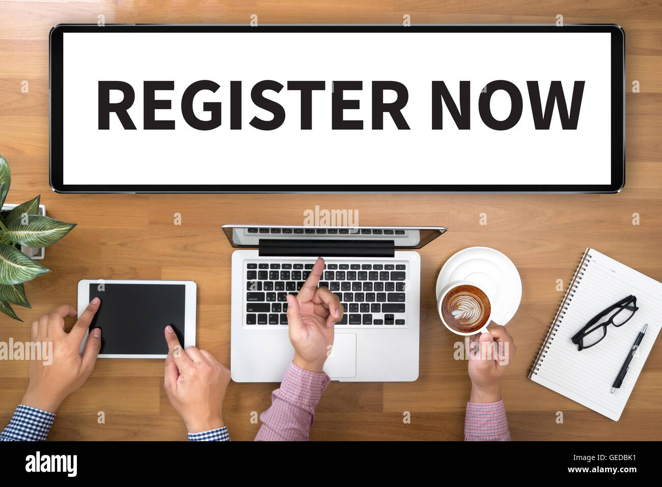 REGISTER NOW Two Businessman working at office desk and using a digital ...