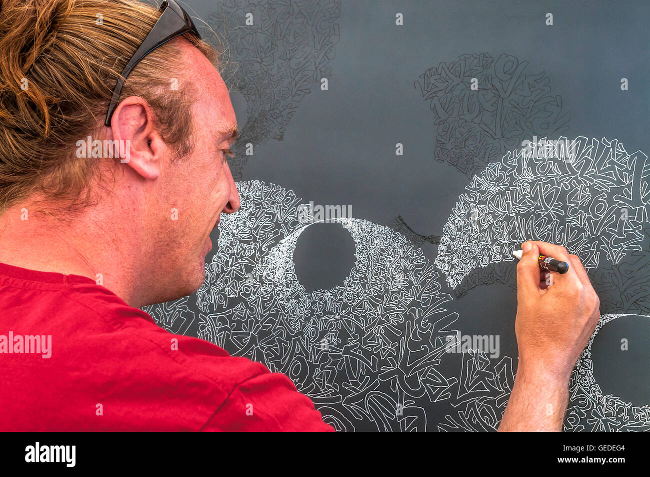 Artist, Gaetan Deffontaines, drawing with white pen liner at artist and ...