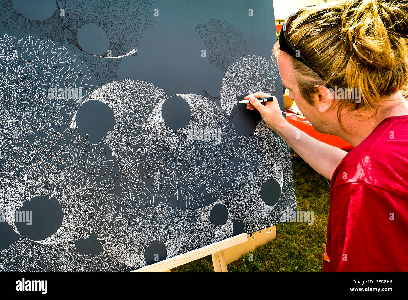 Artist, Gaetan Deffontaines, drawing with white pen liner at artist and ...