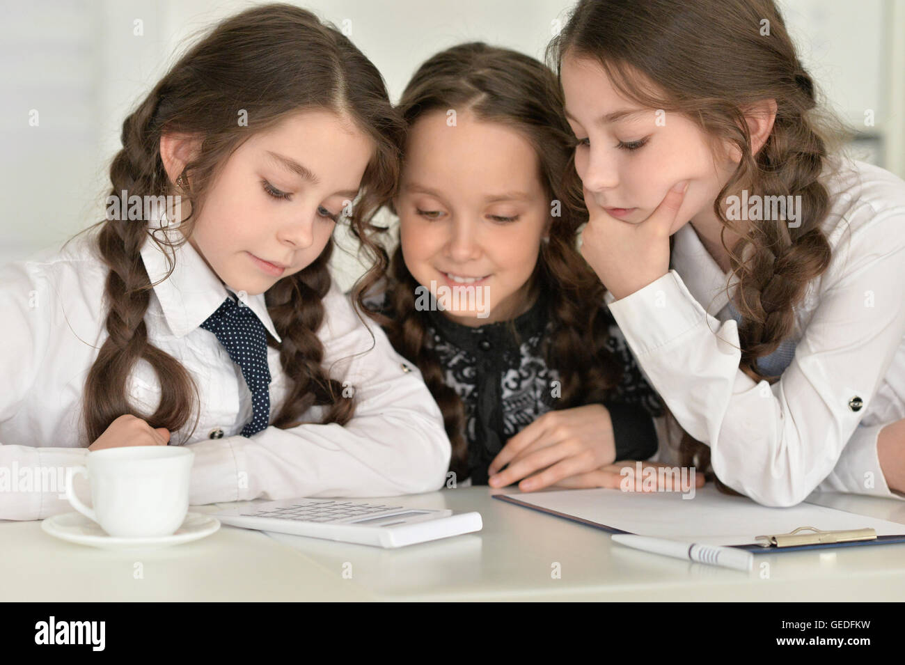 Three little girls making homework Stock Photo - Alamy