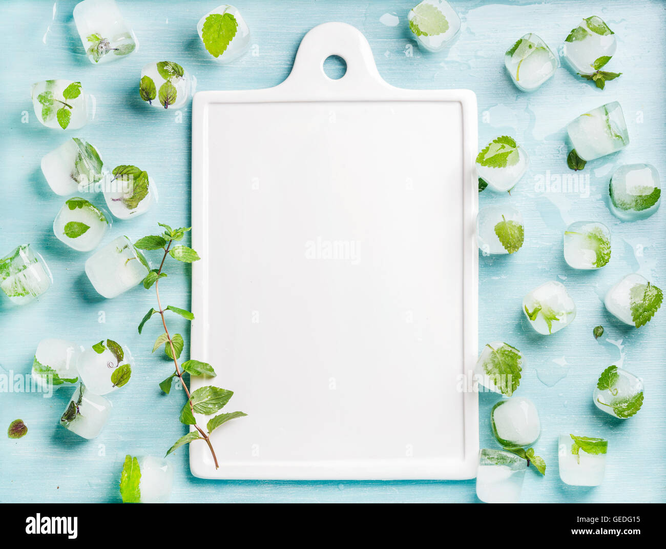 Ice cubes with frozen mint leaves inside on blue Turquoise background ...