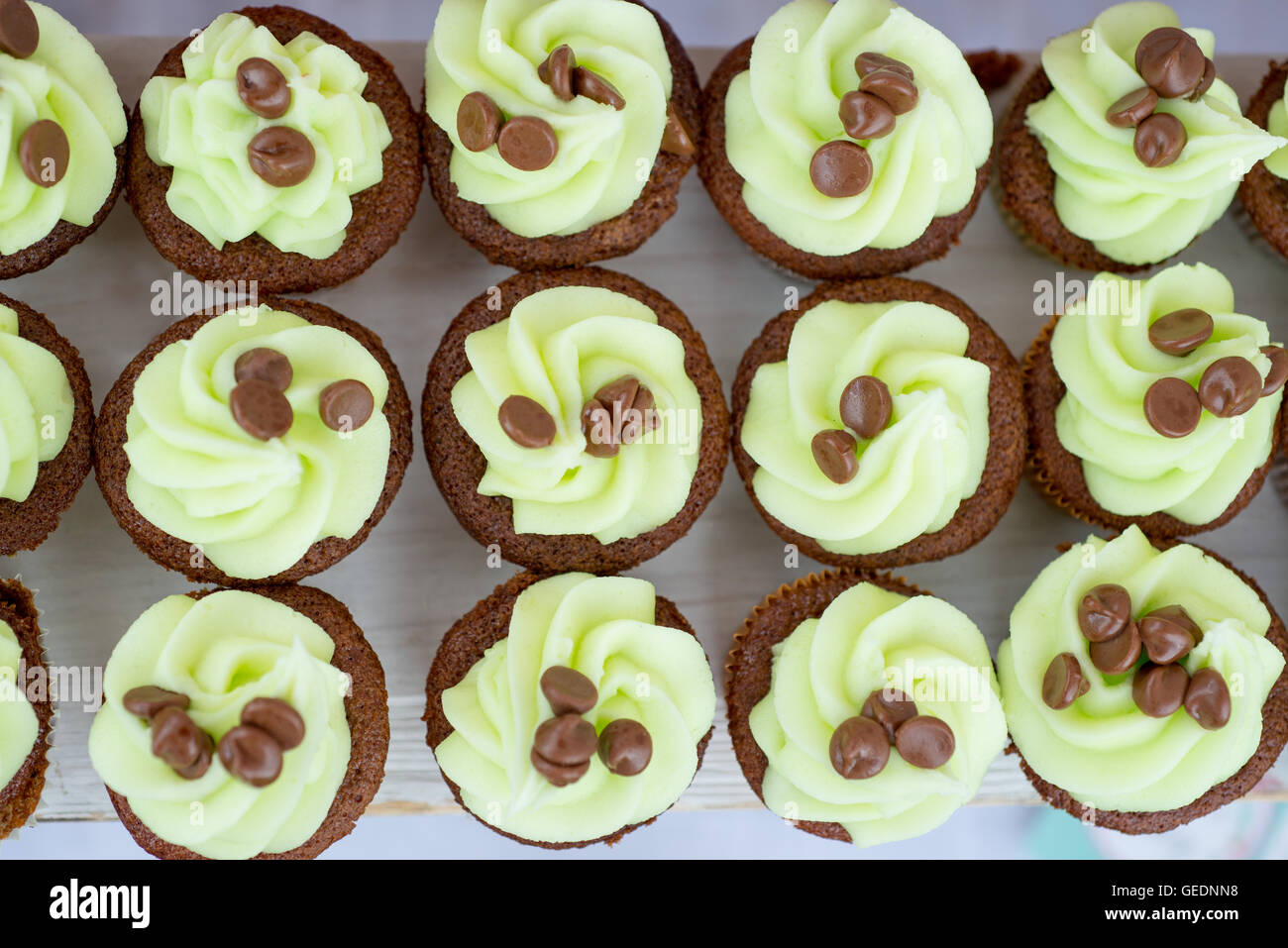Rows of hand decorated cupcakes with green mint coloured icing and ...