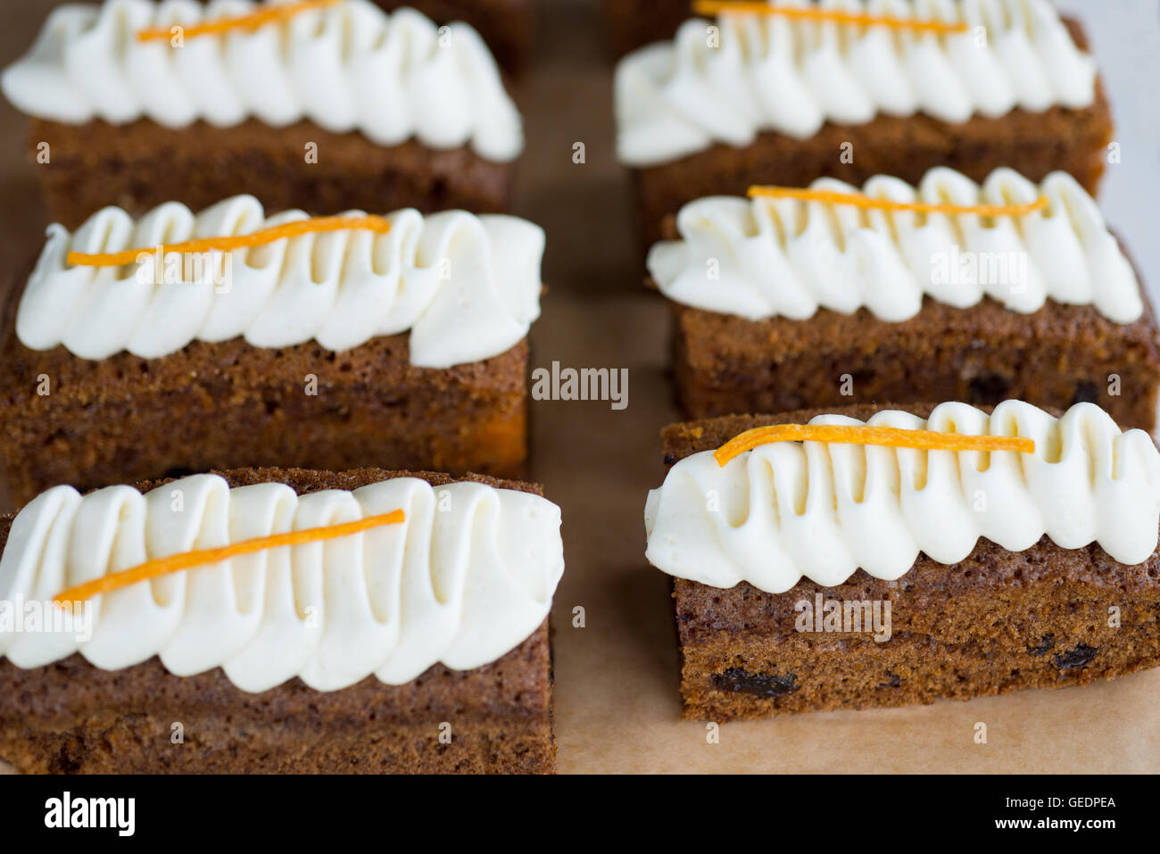 Close up shot of six rectangles of carrot cake. Soft brown cake with ...