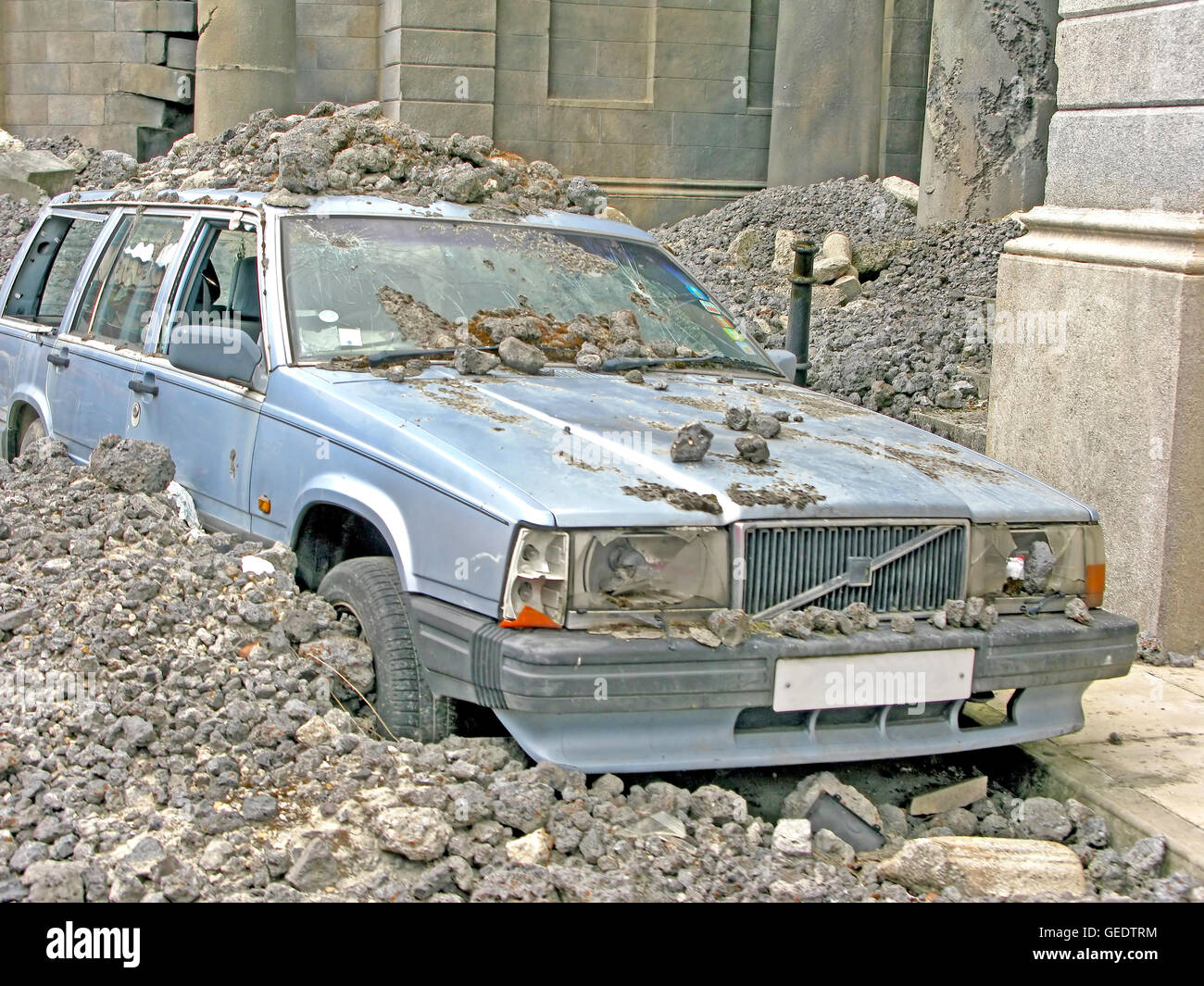 A car in amongst a lot of concrete rubble Stock Photo - Alamy