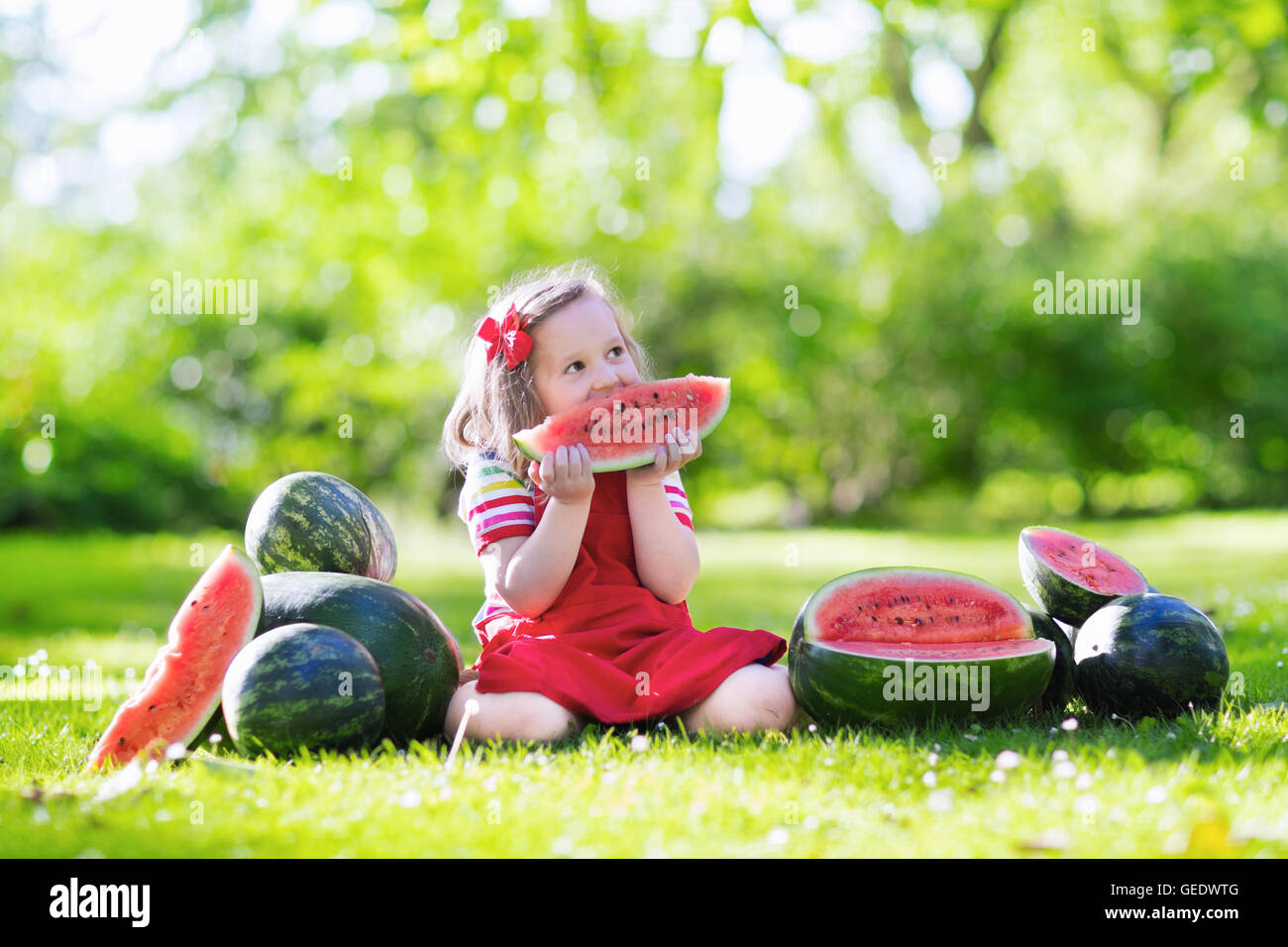 Child eating watermelon in the garden. Kids eat fruit outdoors. Healthy ...