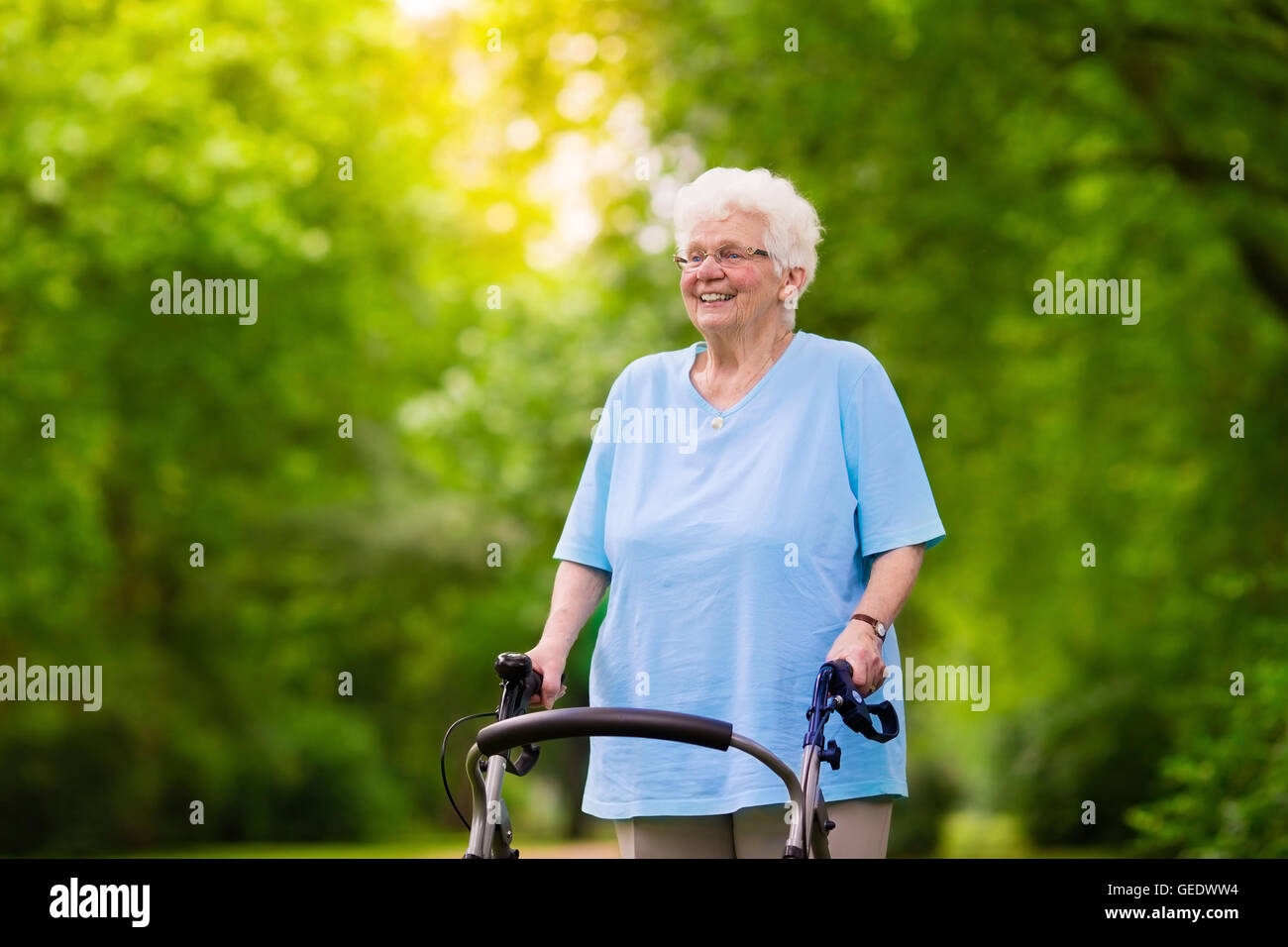 Happy senior handicapped lady with a walking disability enjoying a walk ...