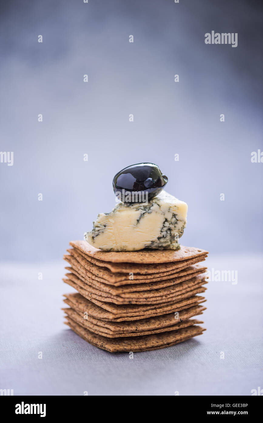 stackpile of crackers with brie and olive Stock Photo - Alamy